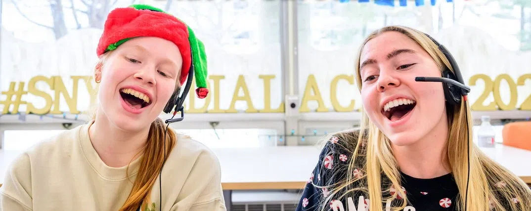 Angel, a volunteer at Dial-A-Carol Hotline in Chicago, cranks up the ...