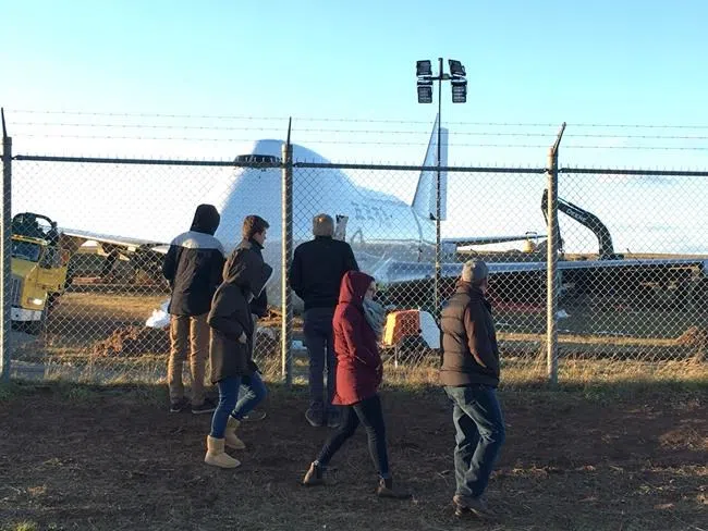 Crowd watches as backhoe rips into mangled plane after Halifax runway ...